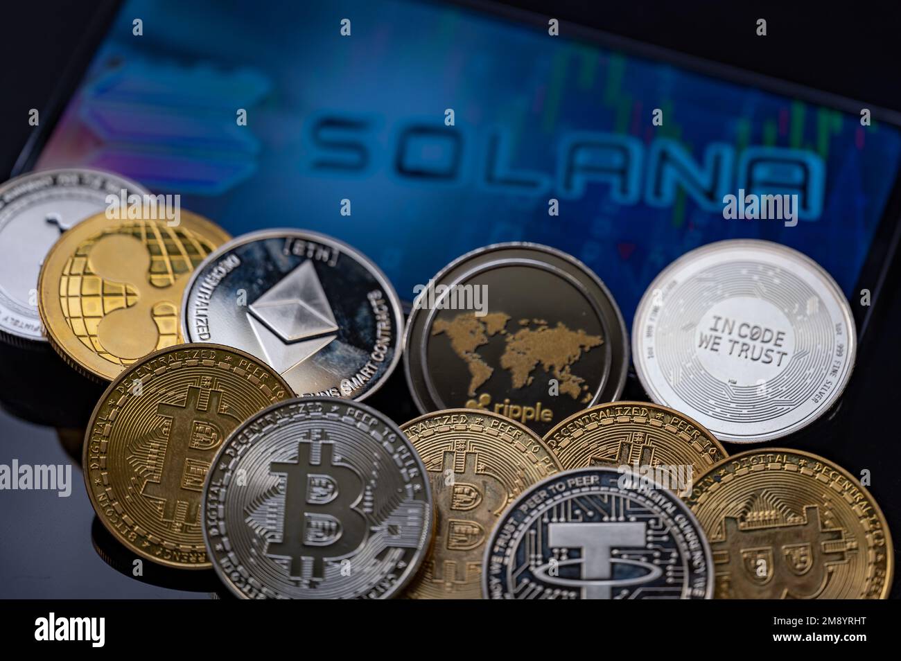 Solana logo displayed on mobile with representation of cryptocurrencies ...