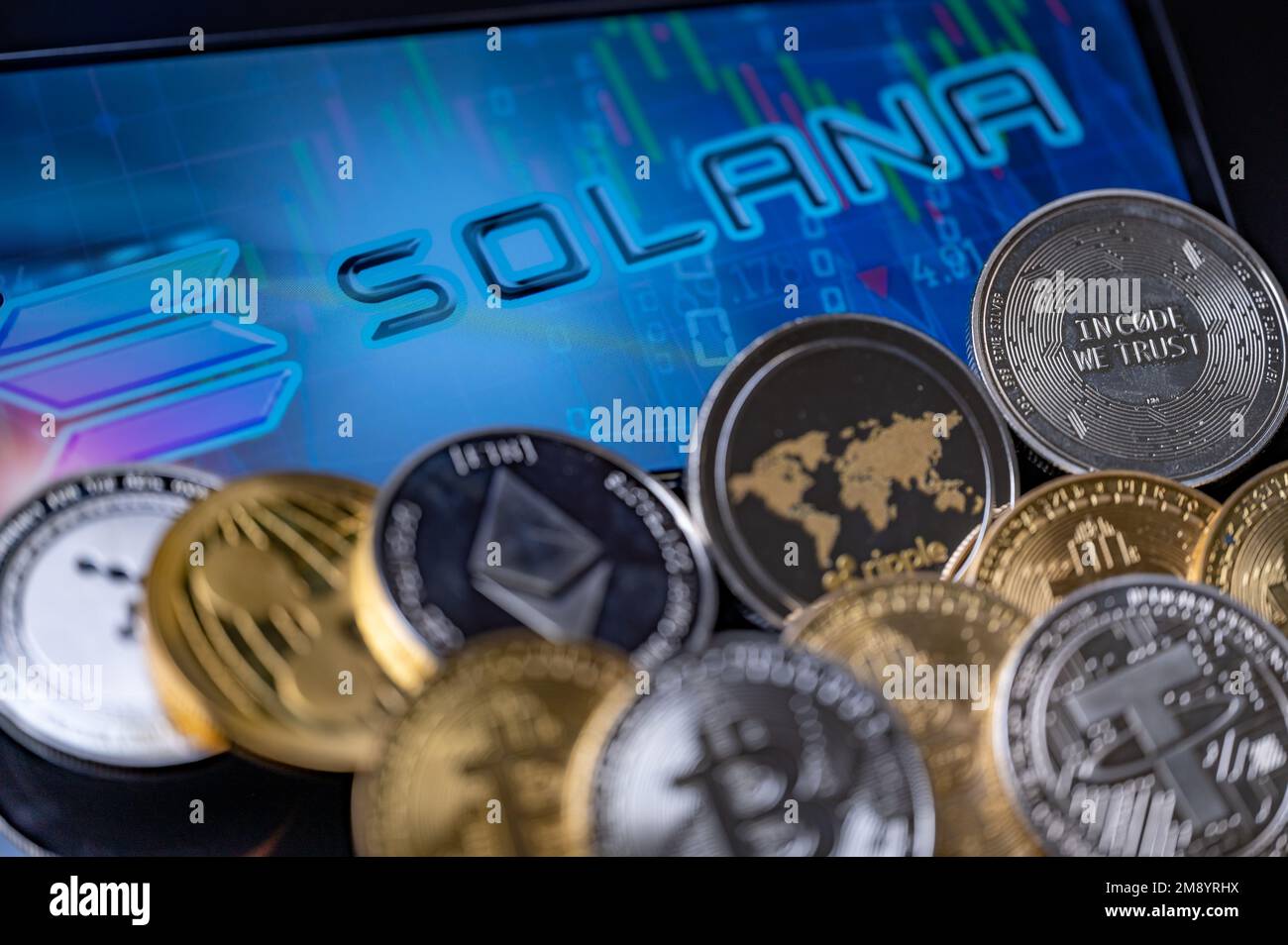 Solana logo displayed on mobile with representation of cryptocurrencies ...
