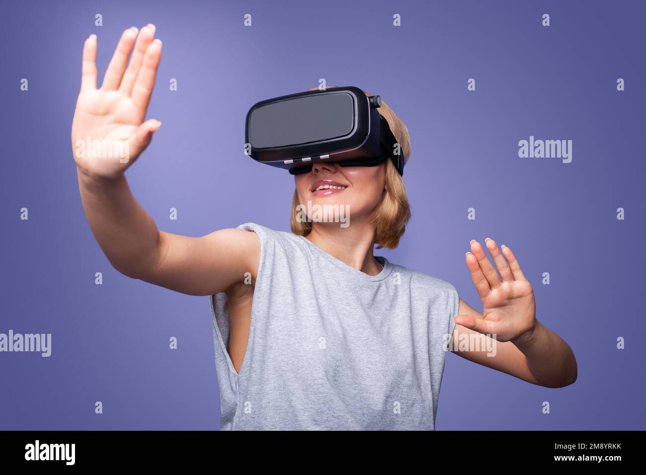 Smiling woman confidence wearing VR headset device touching air during ...