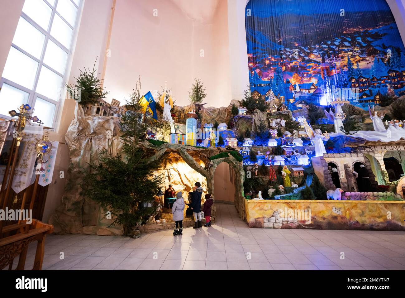 Back of three children looking in Christmas nativity crib scene in ...
