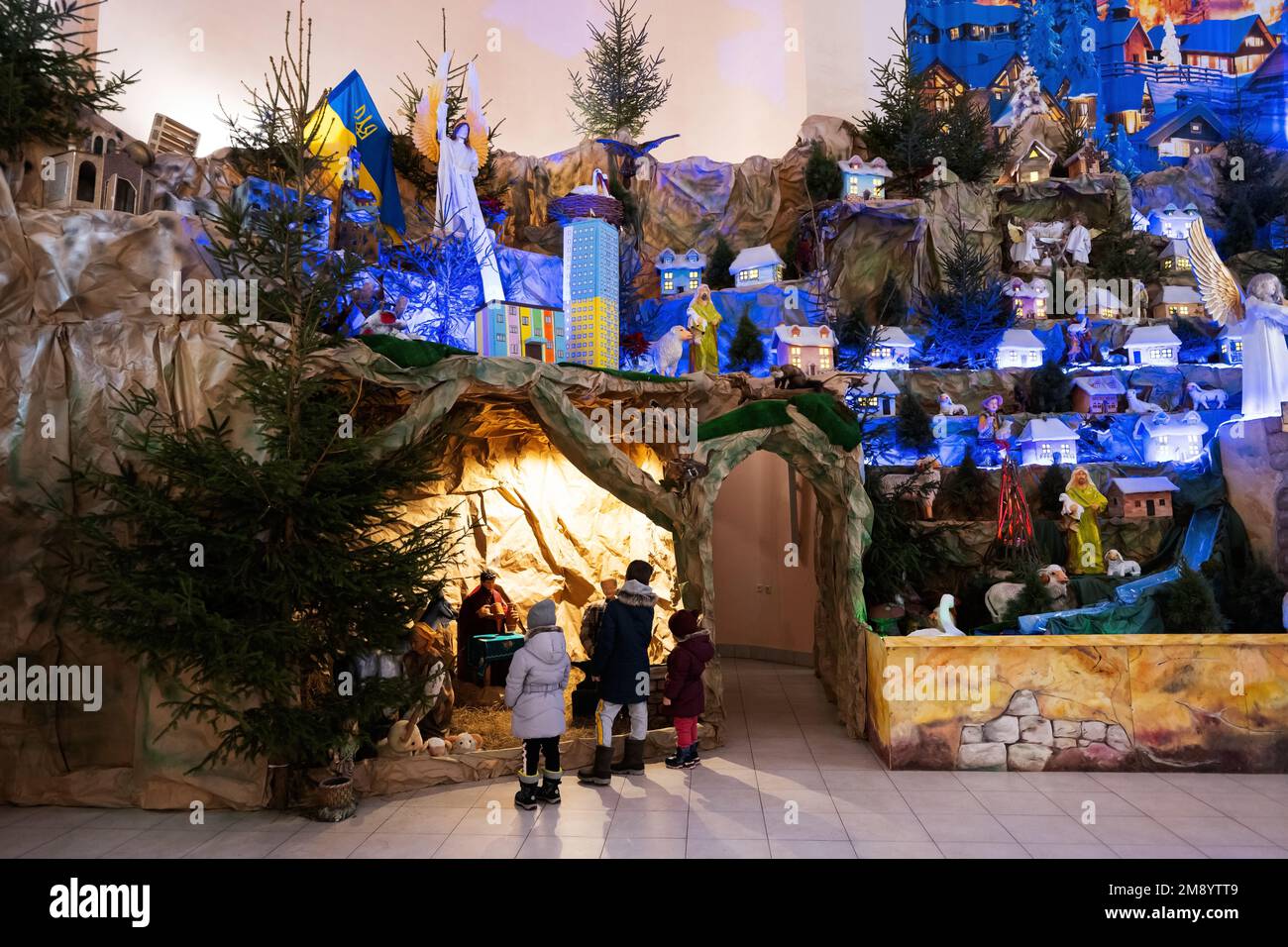 Back of three children looking in Christmas nativity crib scene in ...