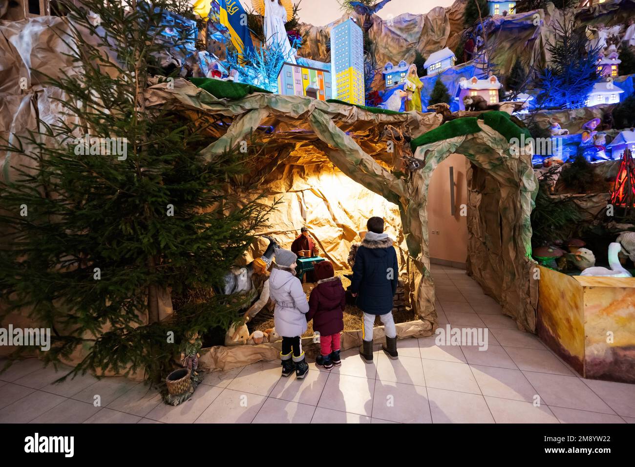Back of three children looking in Christmas nativity crib scene in ...