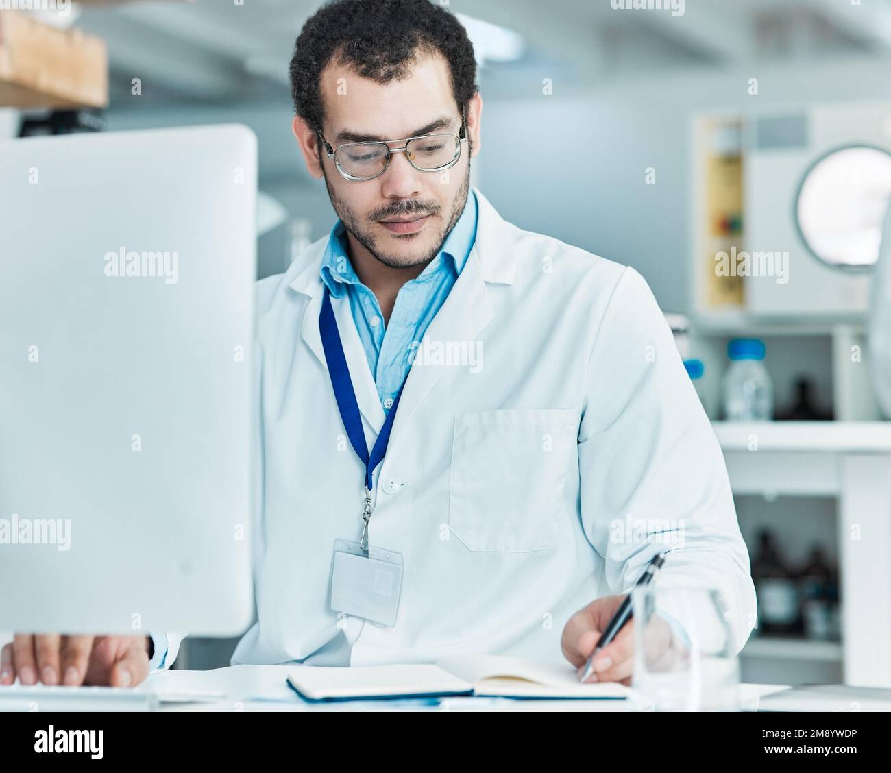 Deducing the facts. a young scientist writing notes while working on a ...