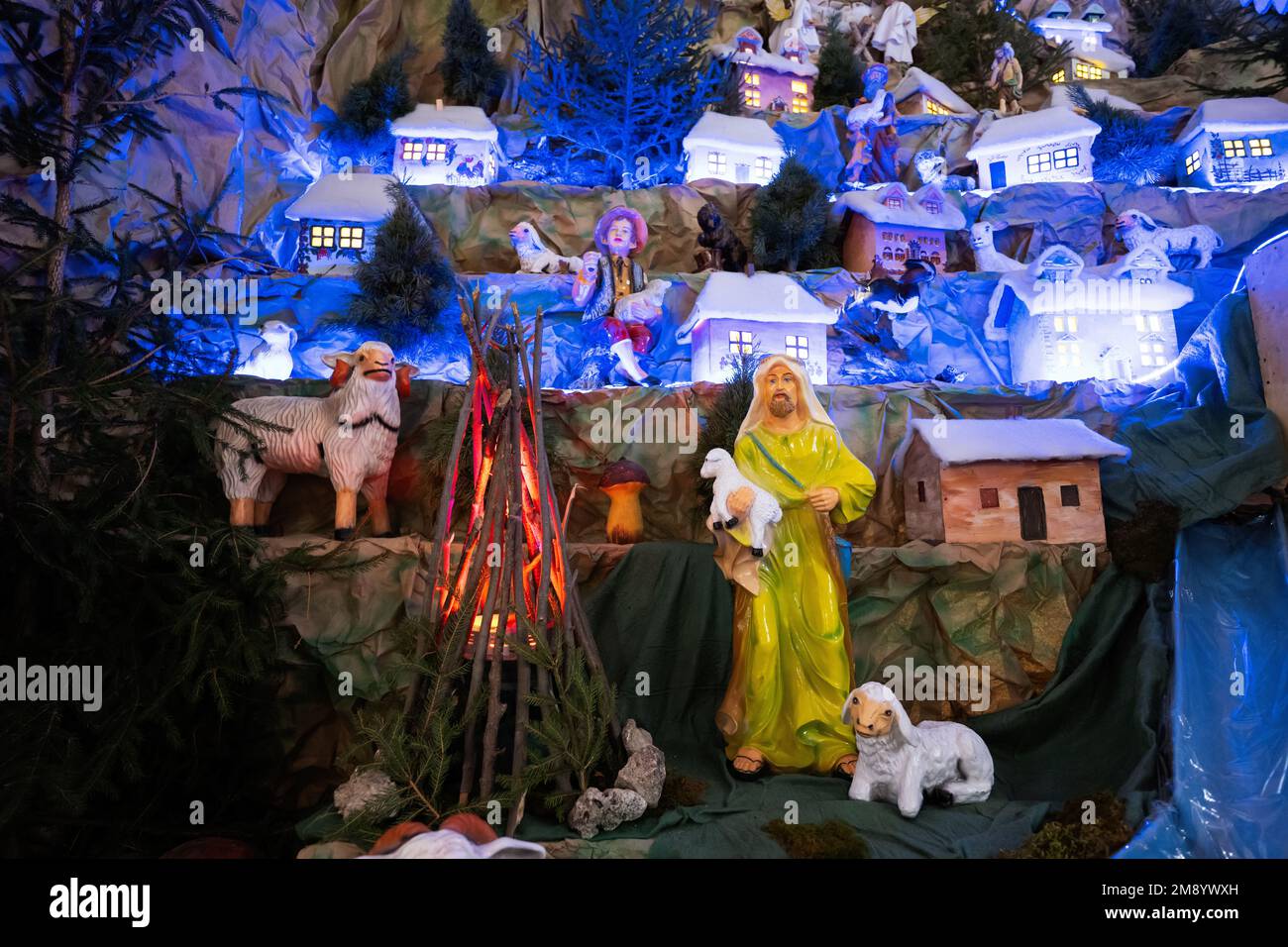 Christmas nativity crib scene in church. Shepherd with a lamb in his ...