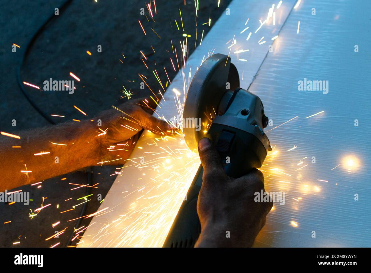 Iron processing work. Metal processing with an angle grinder. Sparks in ...