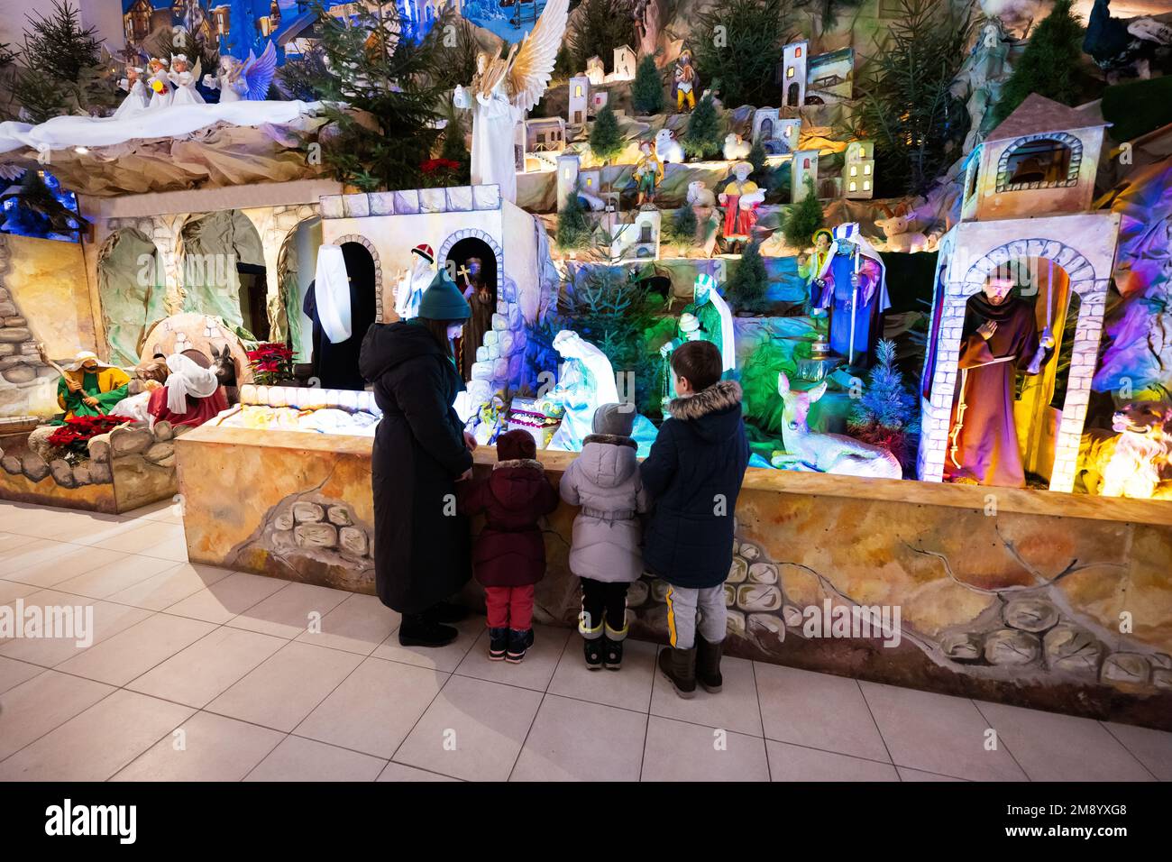 Mother with three children visit Christmas nativity crib scene in ...