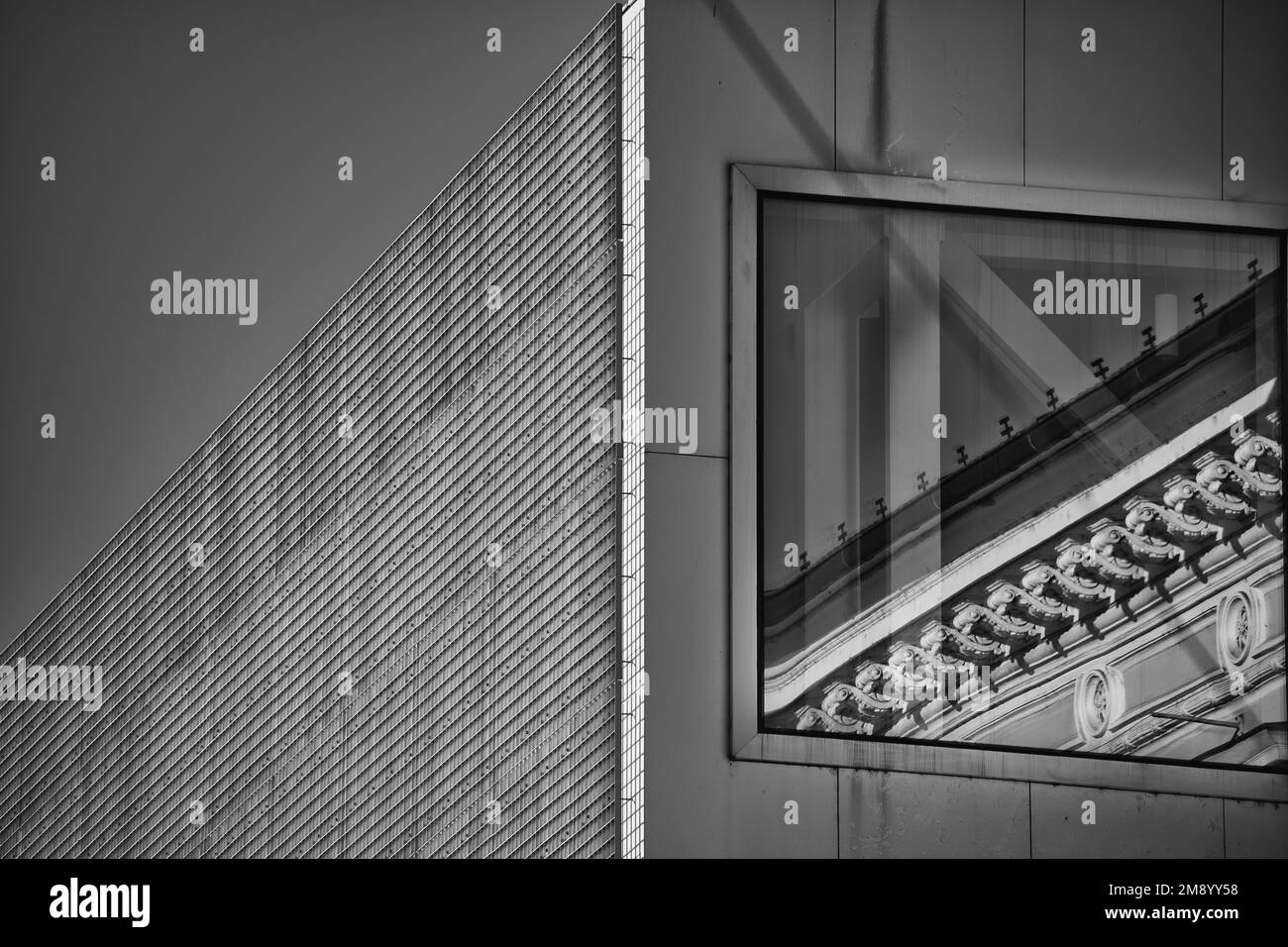 A grayscale of a building with a mirror reflecting crown moulding ...