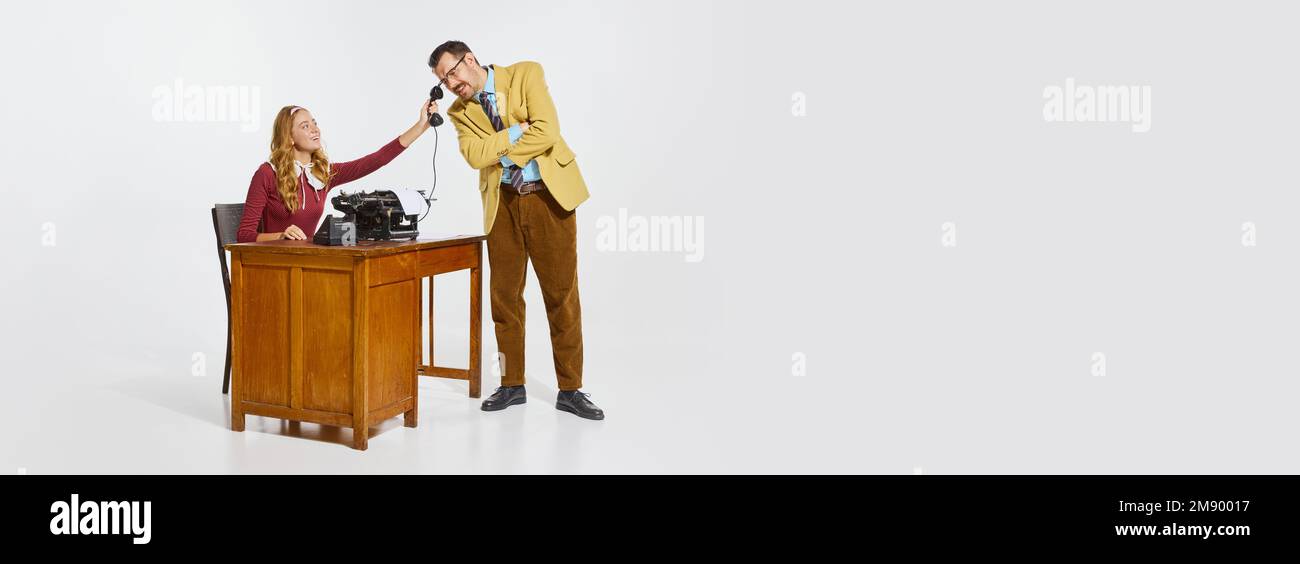 Woman, assistant sitting at the table and giving phone to her boss ...