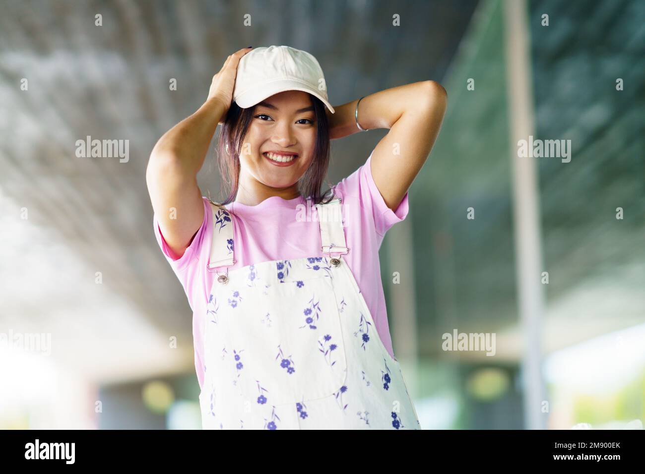 Cheerful Asian female touching head Stock Photo - Alamy
