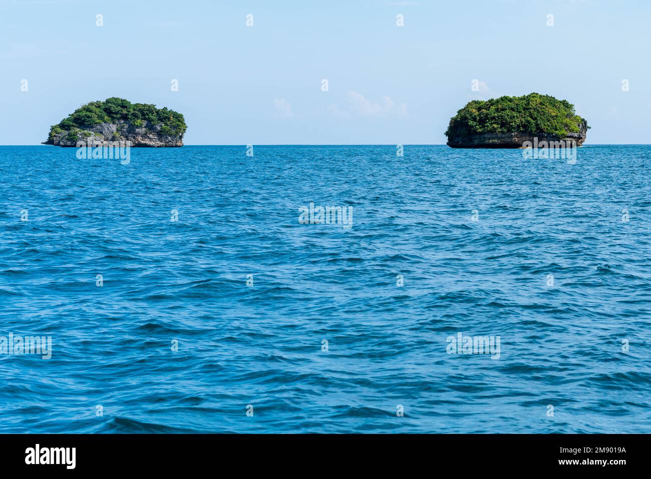 A scenic shot of two small rocky islands in the sea in the 1000 Islands ...