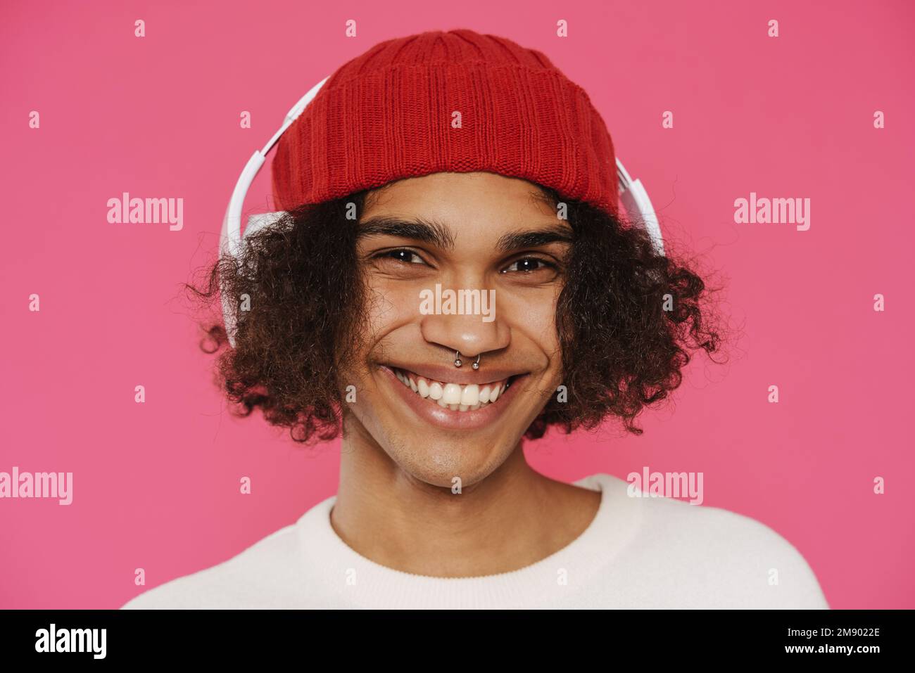 Young caribbean man laughing while listening music with headphones ...
