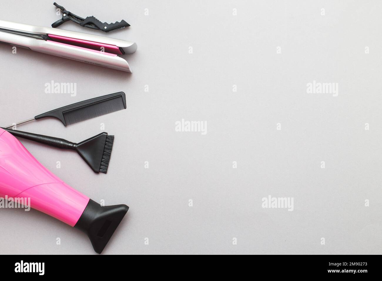 various hairdressing tools like hair dryer, comb on a gray background ...