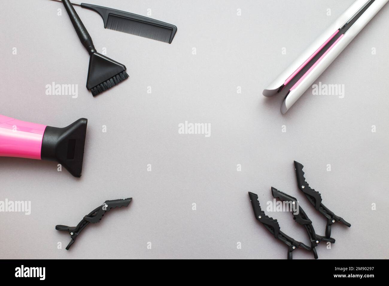 various hairdressing tools like hair dryer, comb on a gray background ...