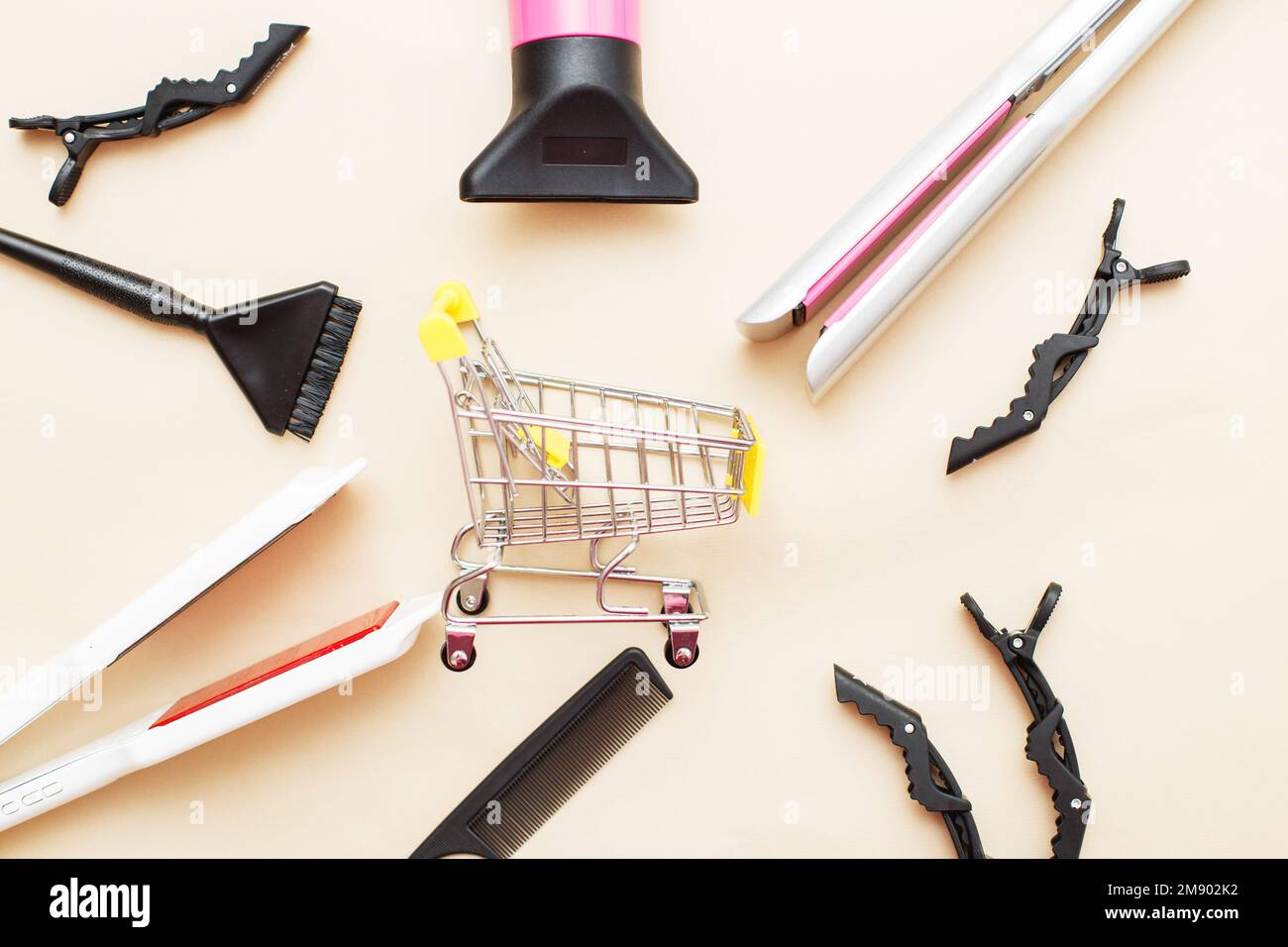 various hairdressing tools with shopping cart on a beige background ...