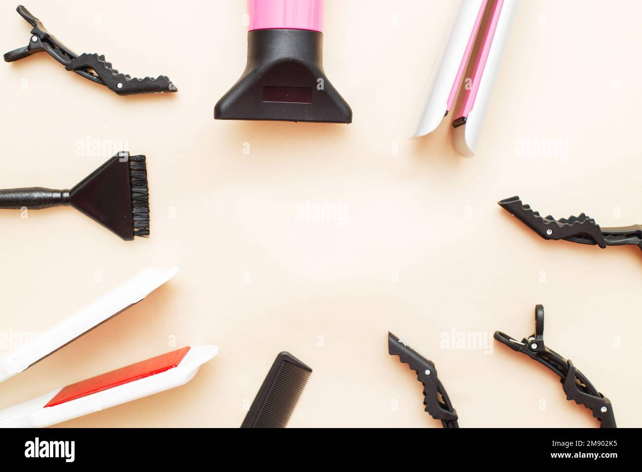various hairdressing tools like hair dryer, comb on a beige background ...