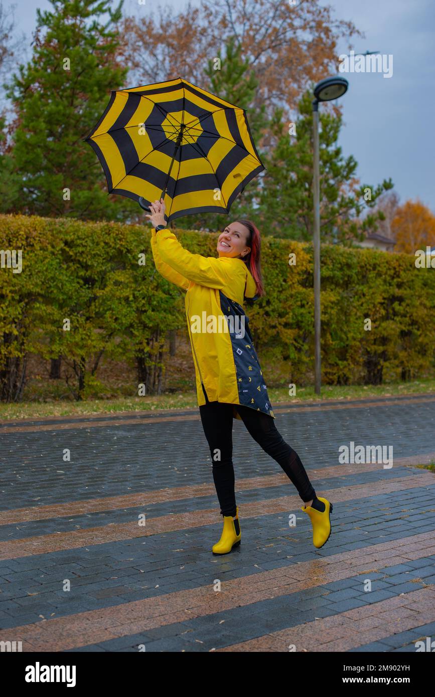 Girl in yellow raincoat umbrella hi-res stock photography and images ...