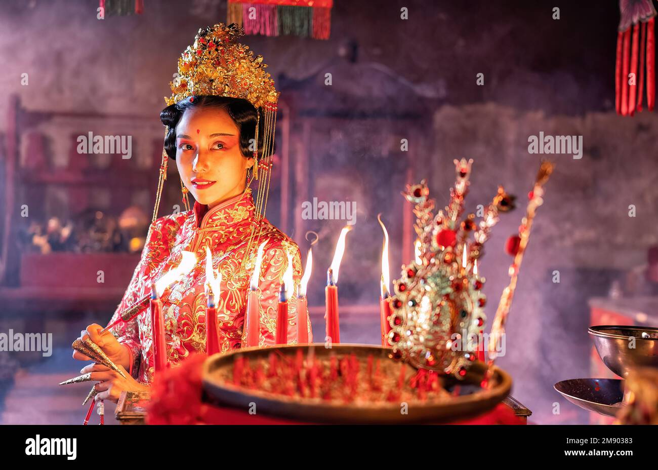 Woman traditional dress in Chinese shrine light up candle joss stick ...