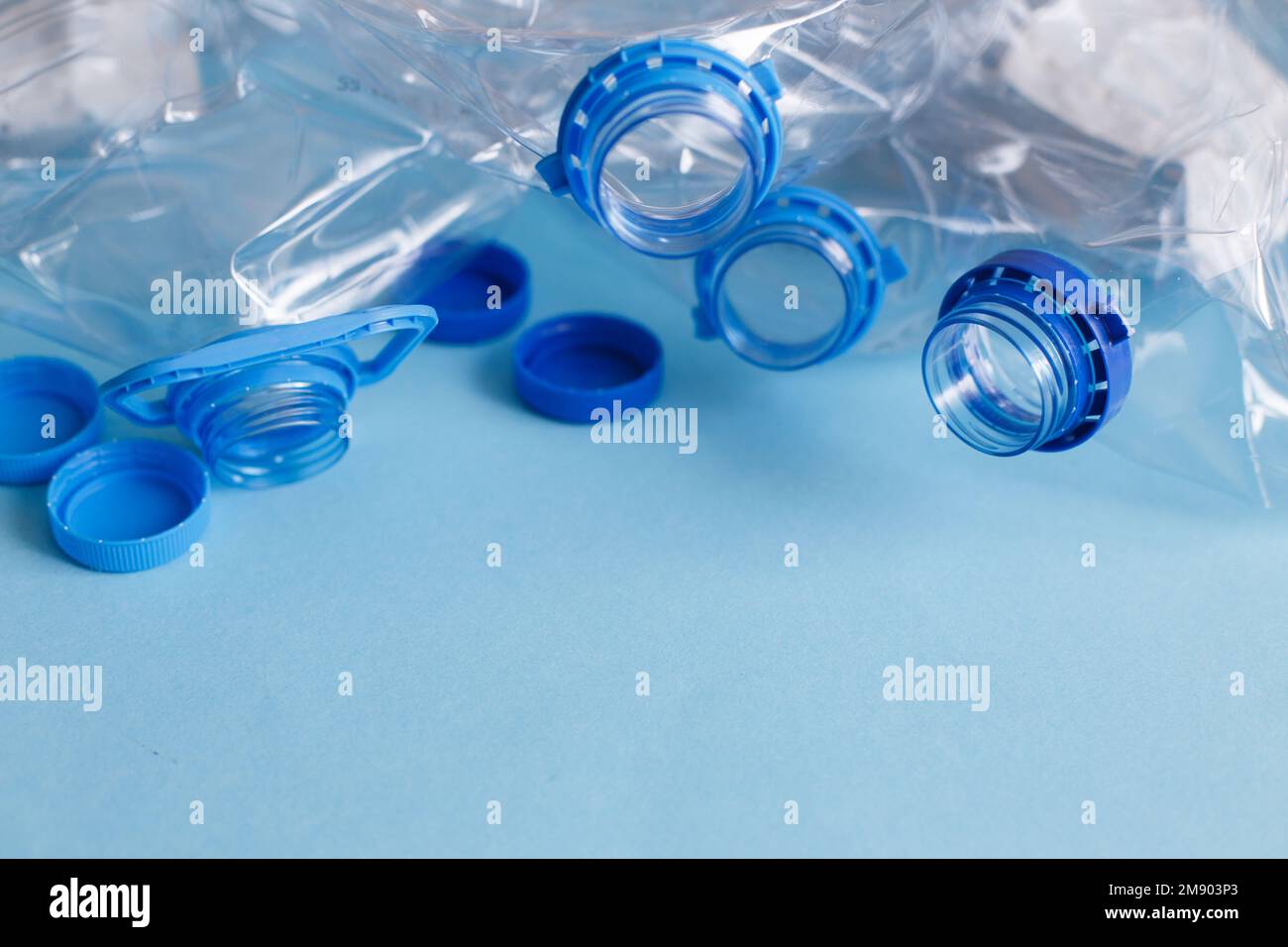 a lot of plastic empty rumpled used bottles on a blue background. waste ...
