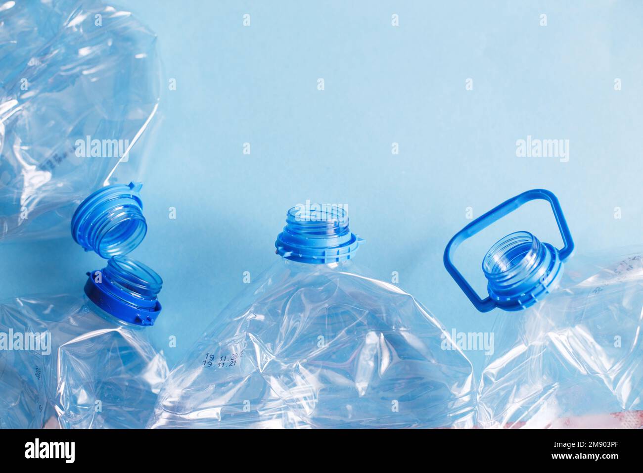 a lot of plastic empty rumpled used bottles on a blue background. waste ...