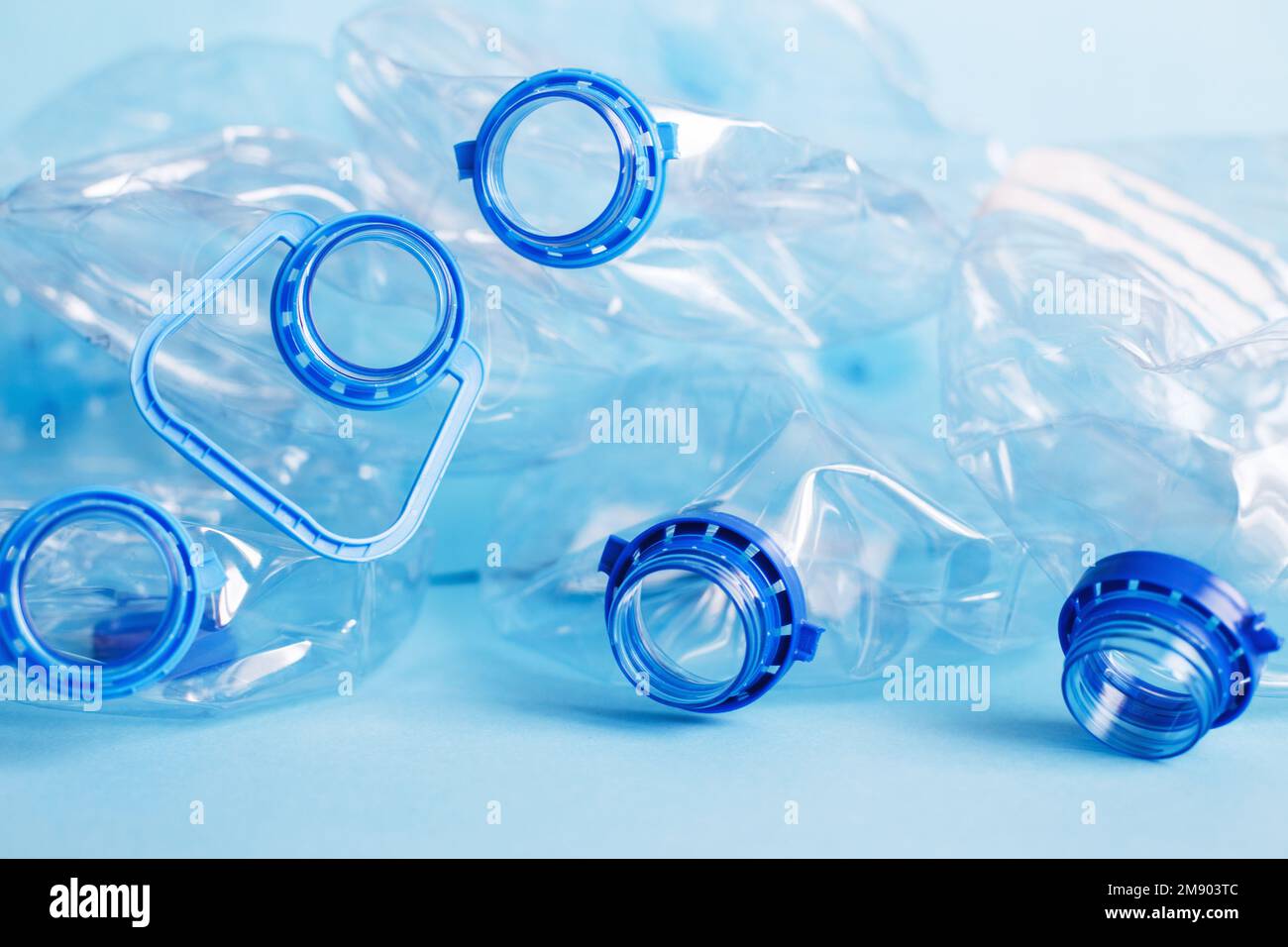 a lot of plastic empty rumpled used bottles on a blue background. waste ...