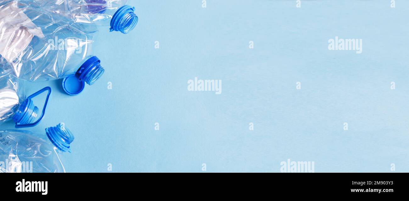 a lot of plastic empty rumpled used bottles on a blue background. waste ...