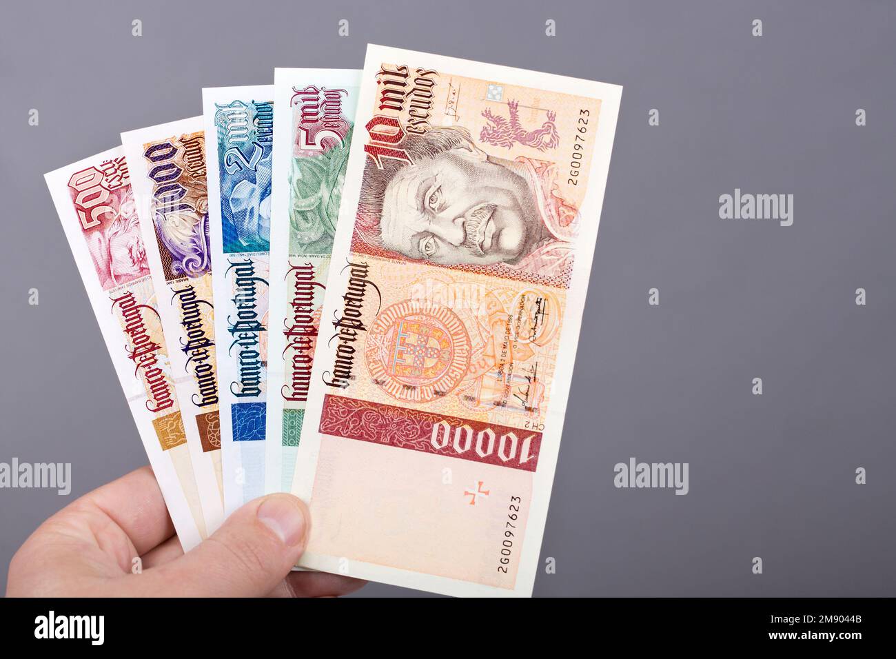 Portuguese money - Escudo in the hand on a gray background Stock Photo ...