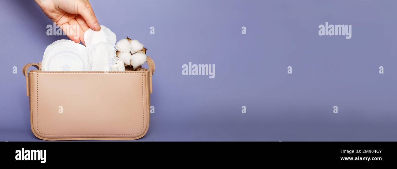 Women's hand takes out panty liner from pink cosmetic bag with tampons ...