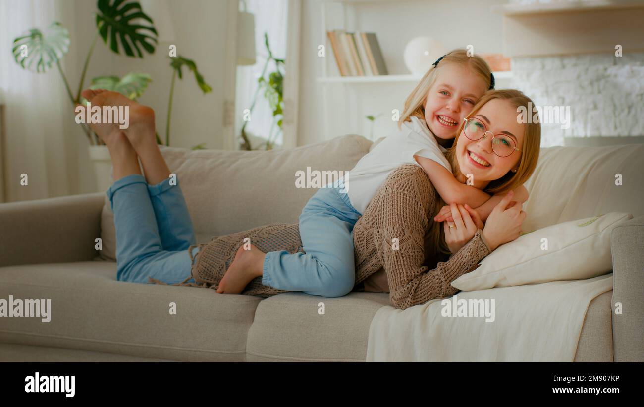 Caucasian mother in glasses lying on couch sofa in home living room ...