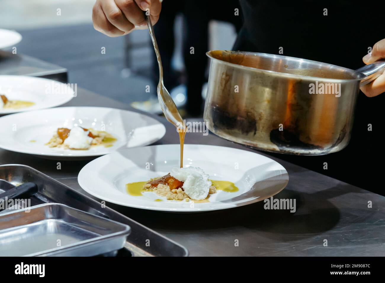 professional chef cooking add some sauce to the dessert dish ...
