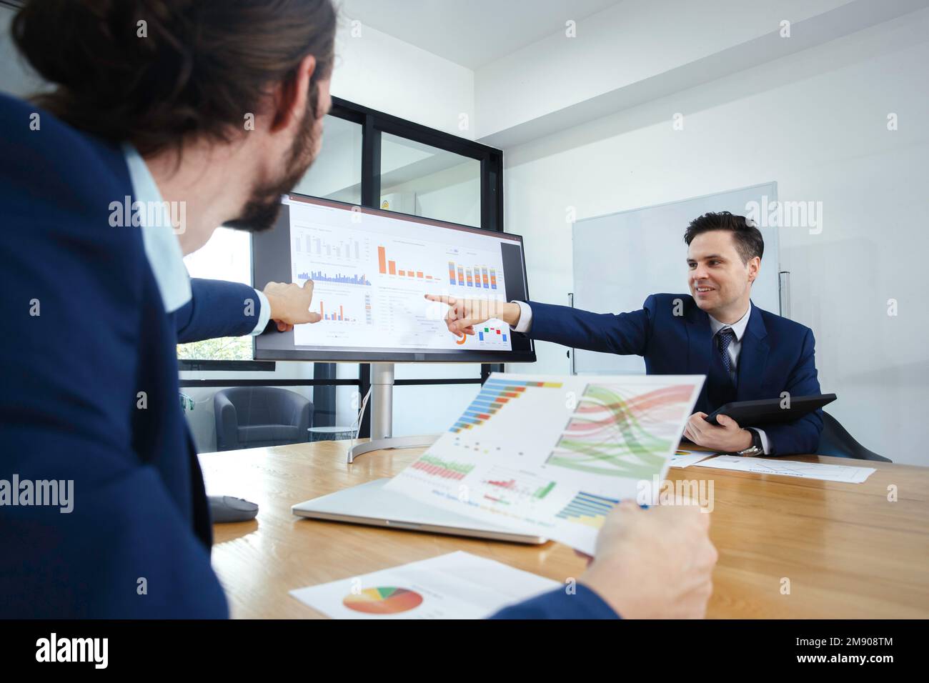 Two young investor businessmen meeting to analysis risk and profit ...