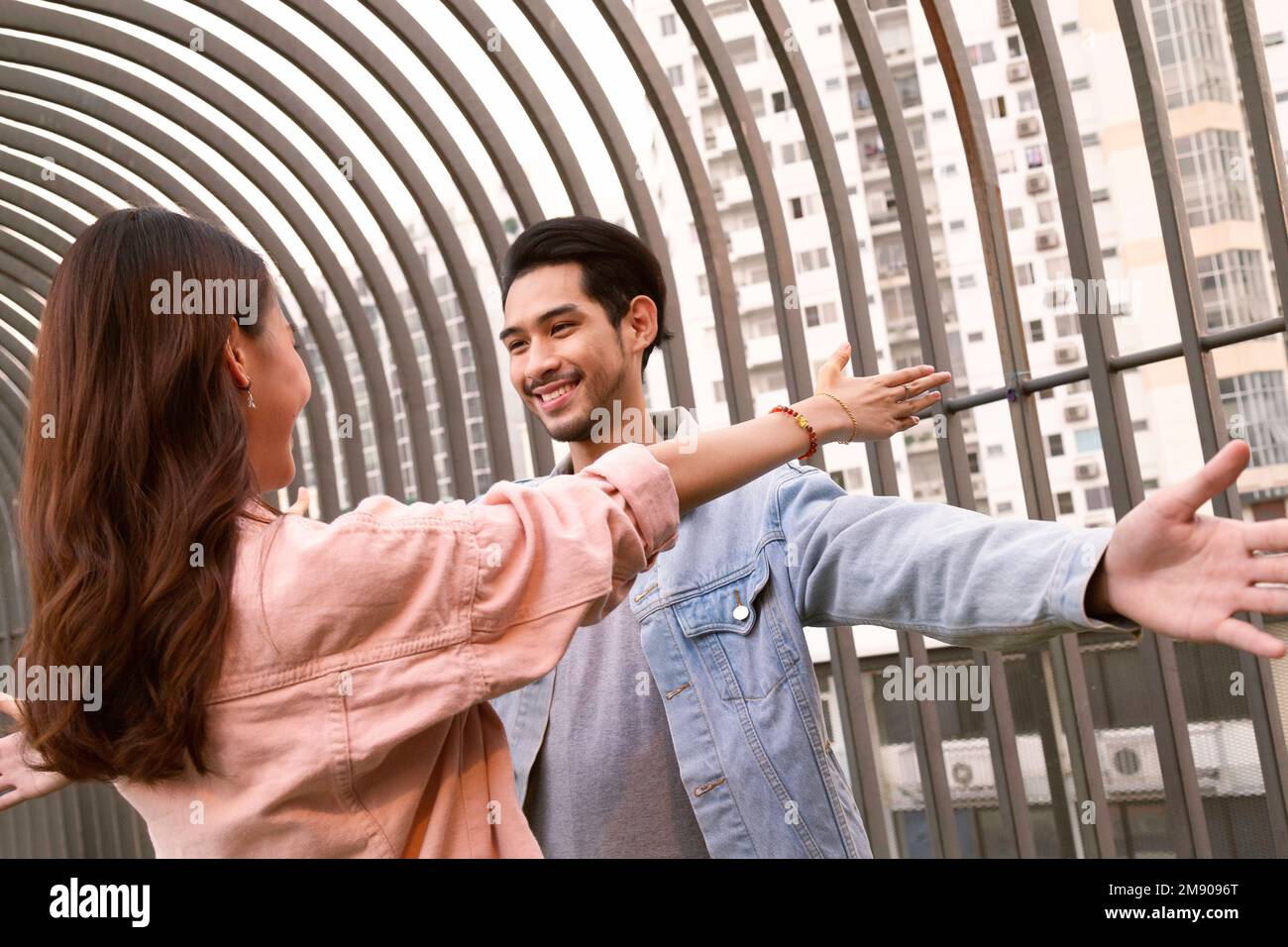 Asian happy smiling woman and man running open arms to embrace to ...