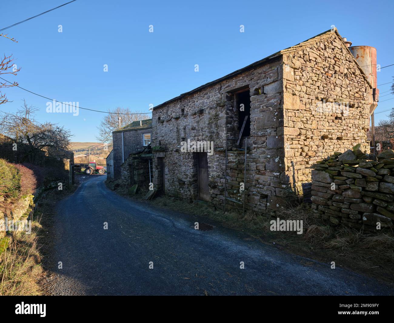 Cluster of farm buildings with bright blue sky ,distant hills and rough ...