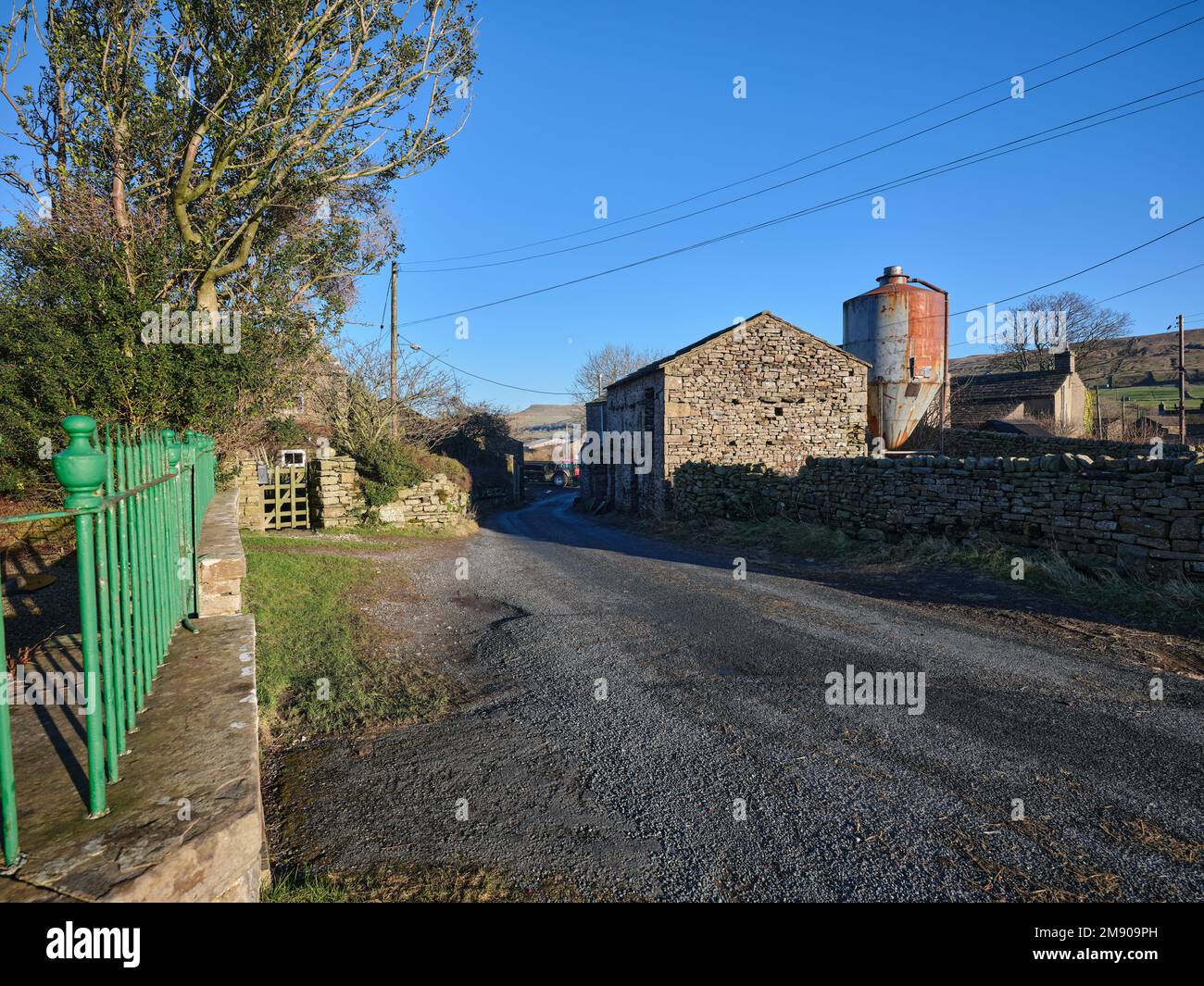 Cluster of farm buildings with bright blue sky ,distant hills and rough ...