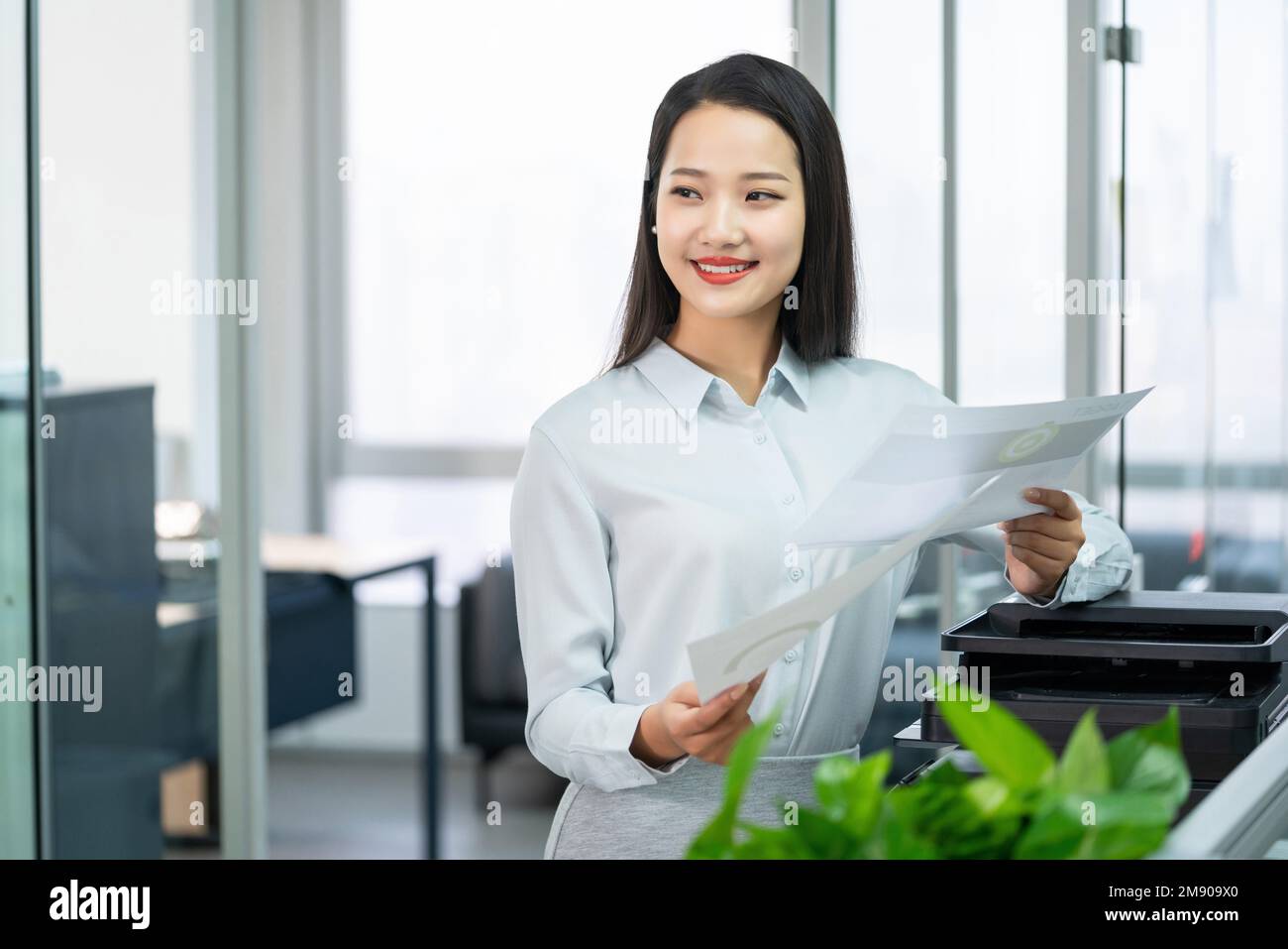 Young business lady use printer Stock Photo - Alamy