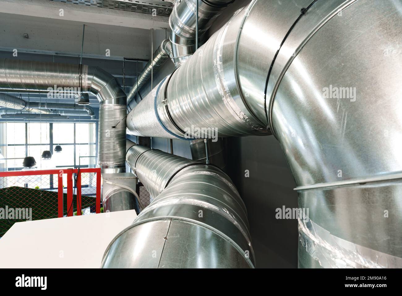 Silver ventilation pipes hanging from the ceiling inside the building ...