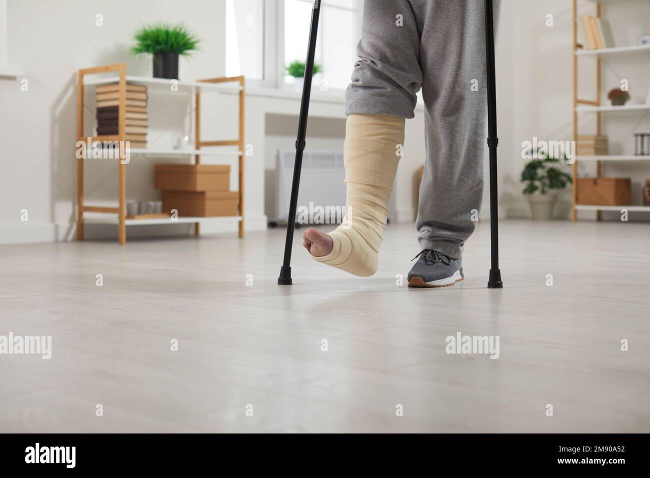 Young man with broken leg or foot injury is undergoing rehabilitation ...