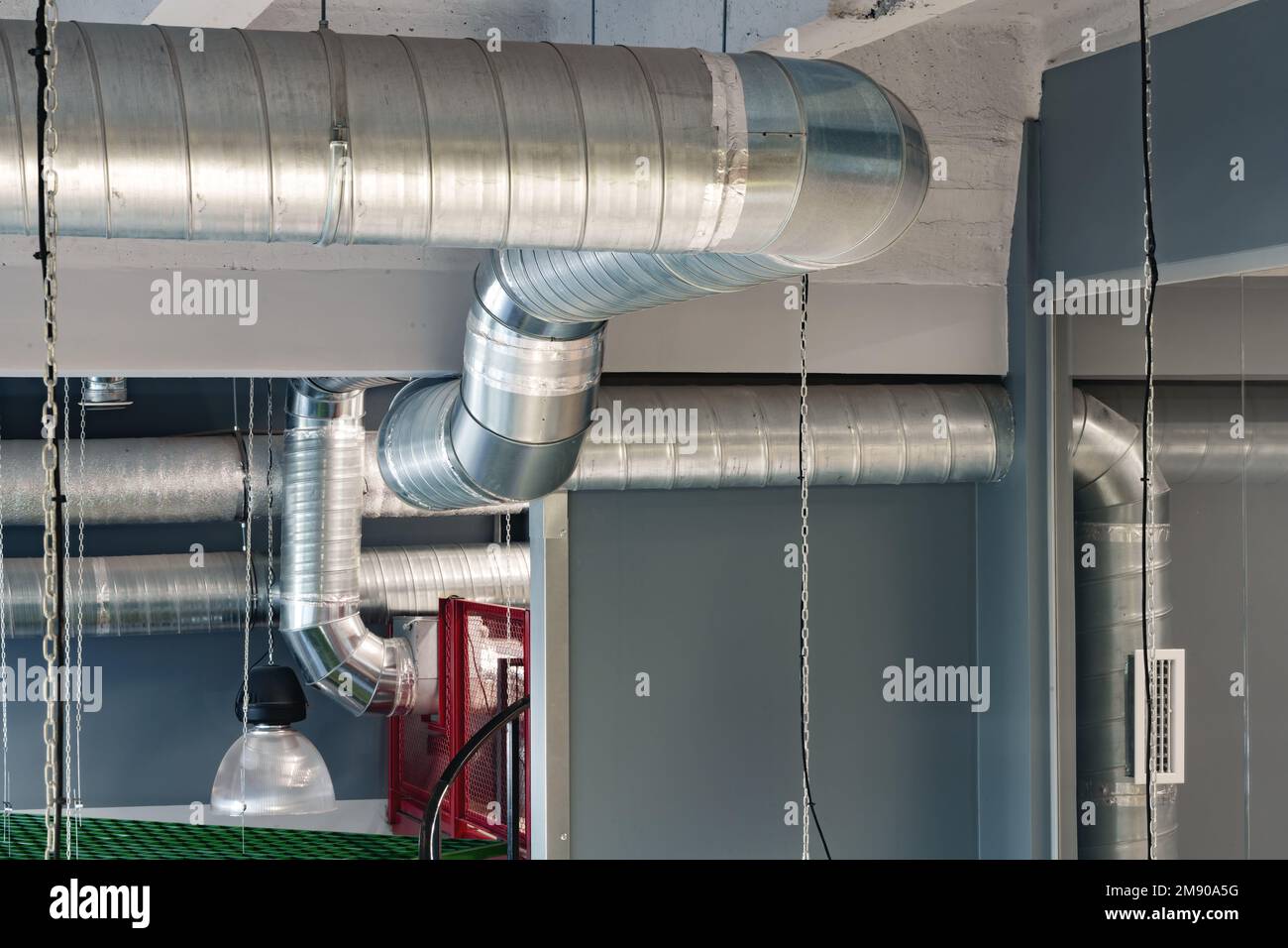 Silver ventilation pipes hanging from the ceiling inside the building ...