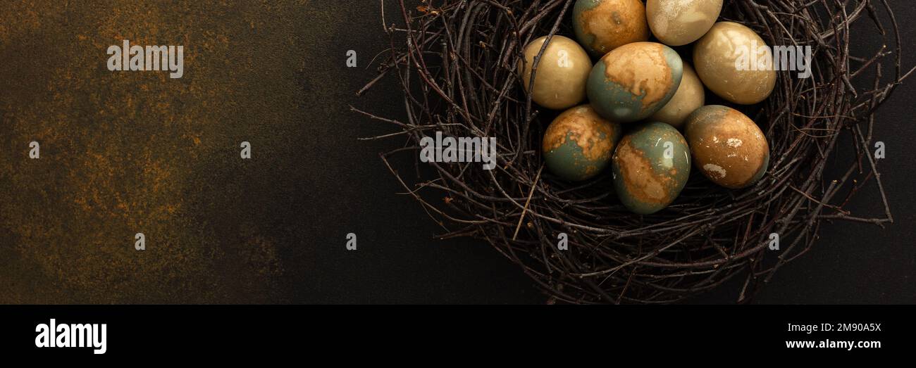 Cosmic Easter eggs in a nest on a brown background, top view, copy ...