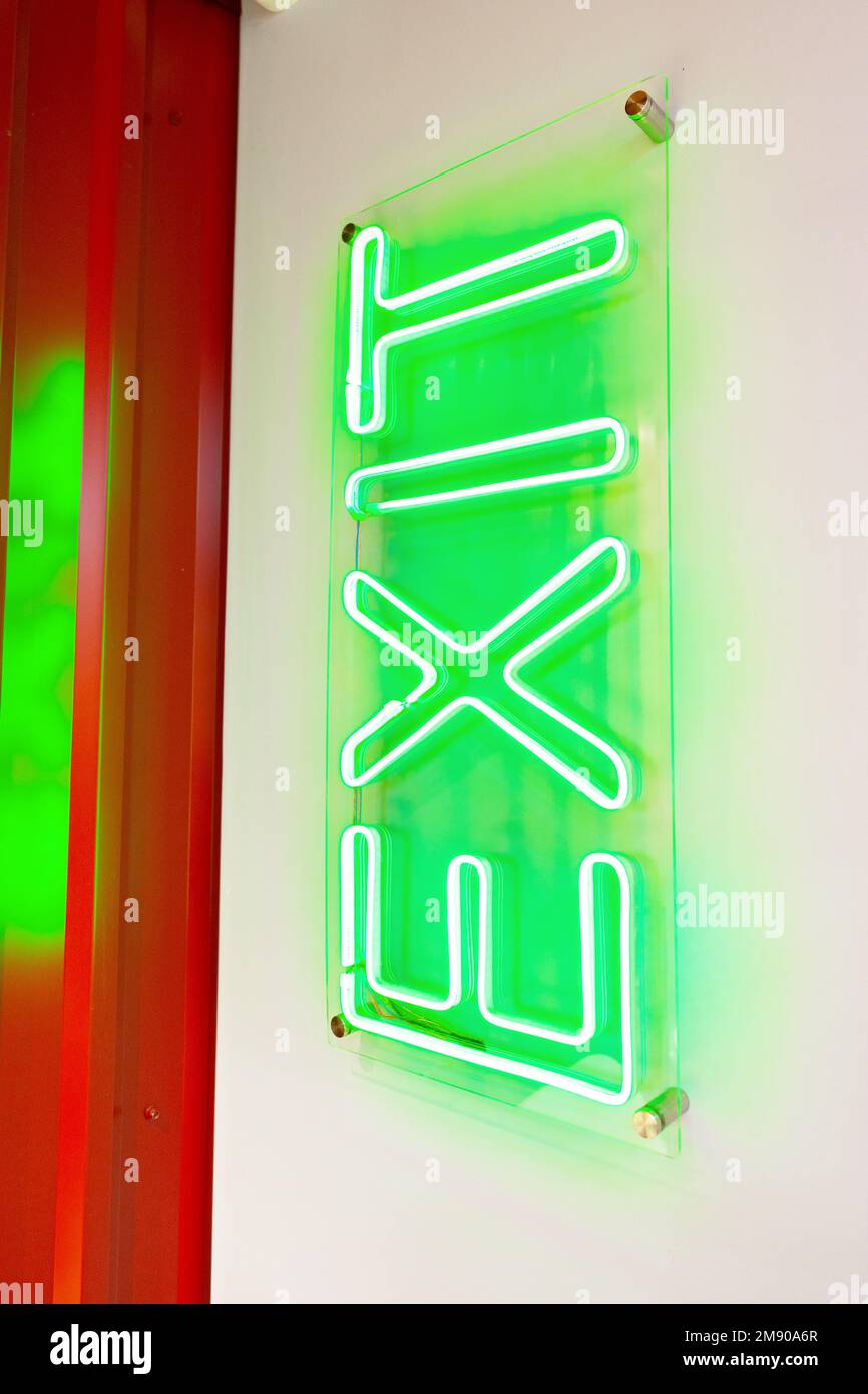 Exit sign green light on the wall background Stock Photo - Alamy