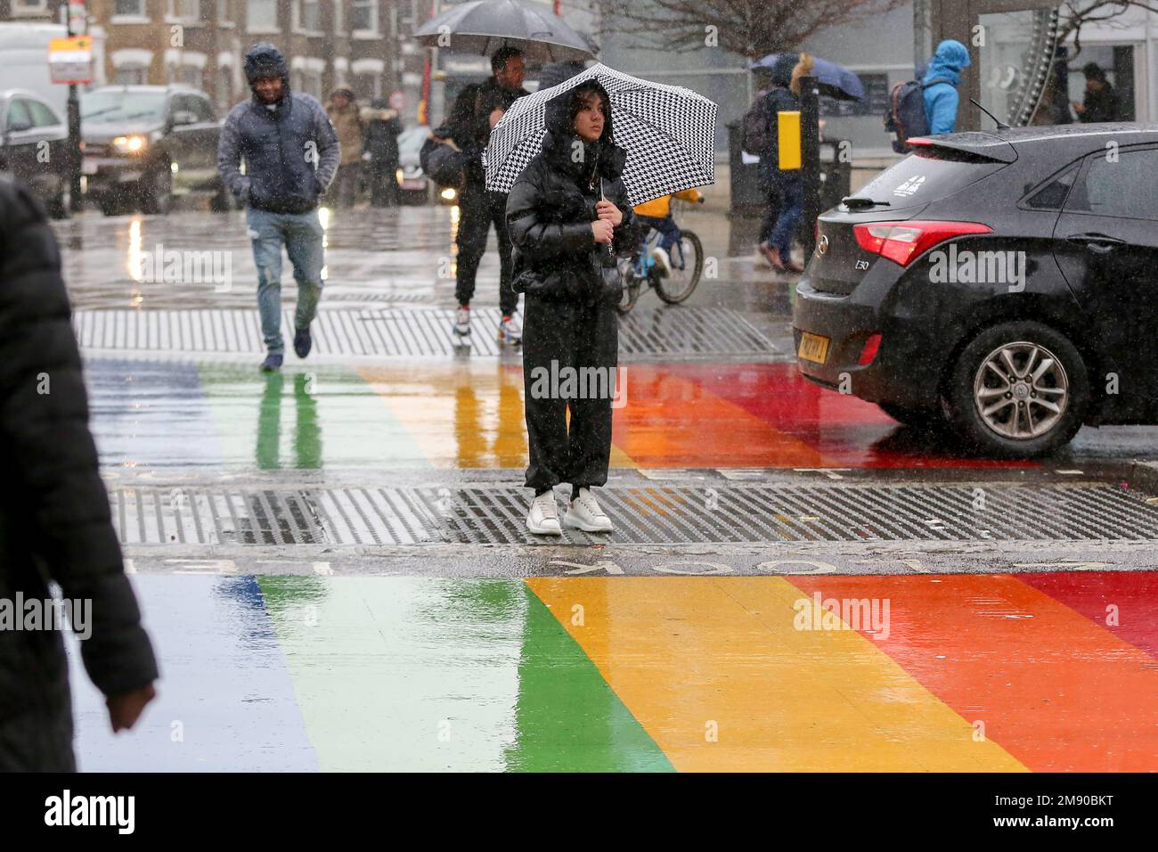 London, UK. 14th Jan, 2023. A woman shelters under an umbrella at a ...