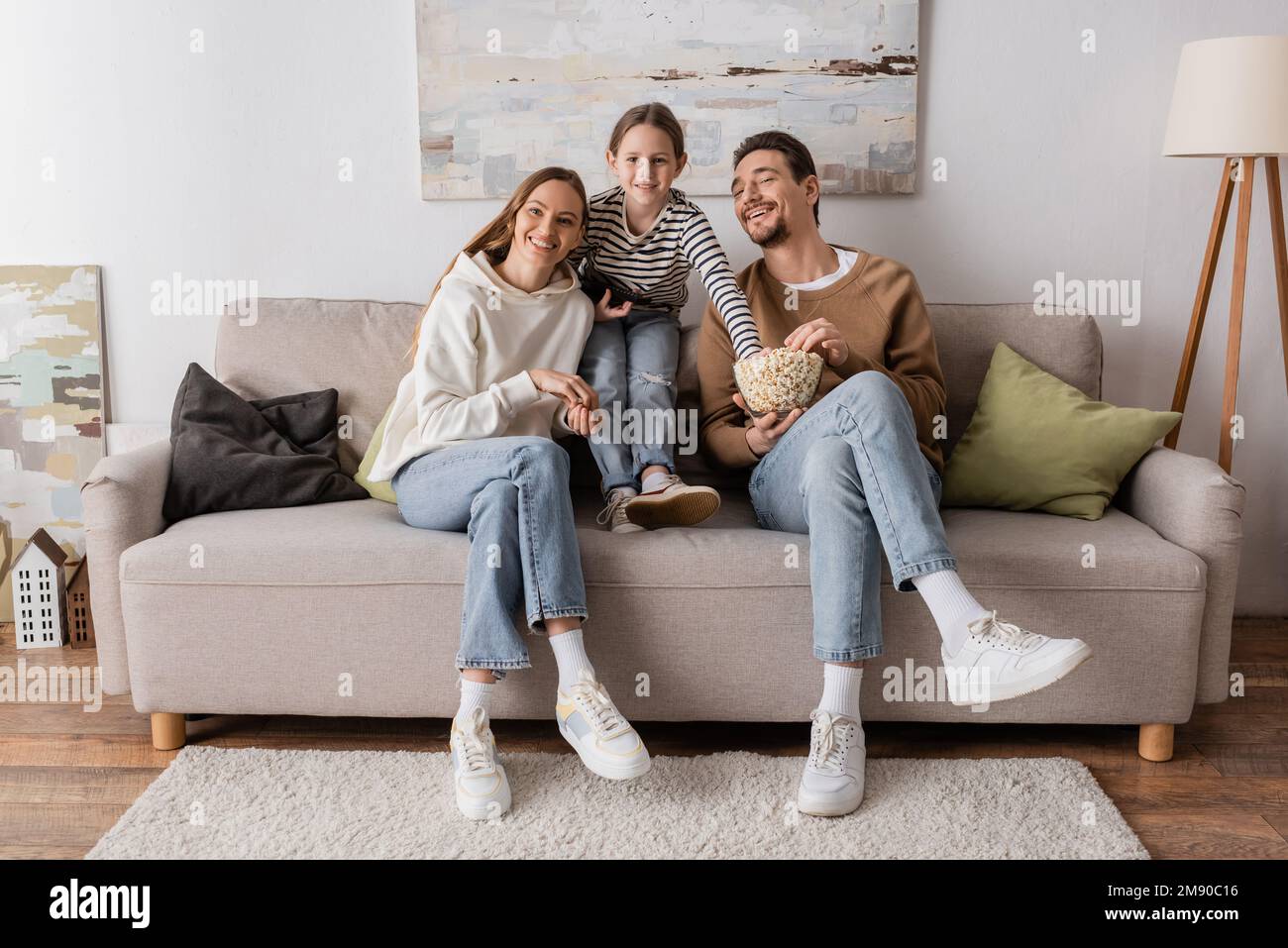 full length of happy kid with remote controller watching movie with ...