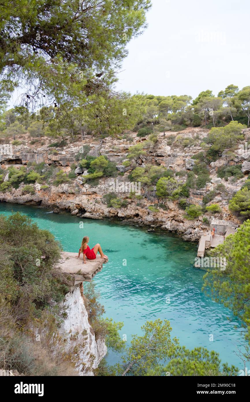 Attractive blonde woman in red dress on the beach of Majorca Spain ...