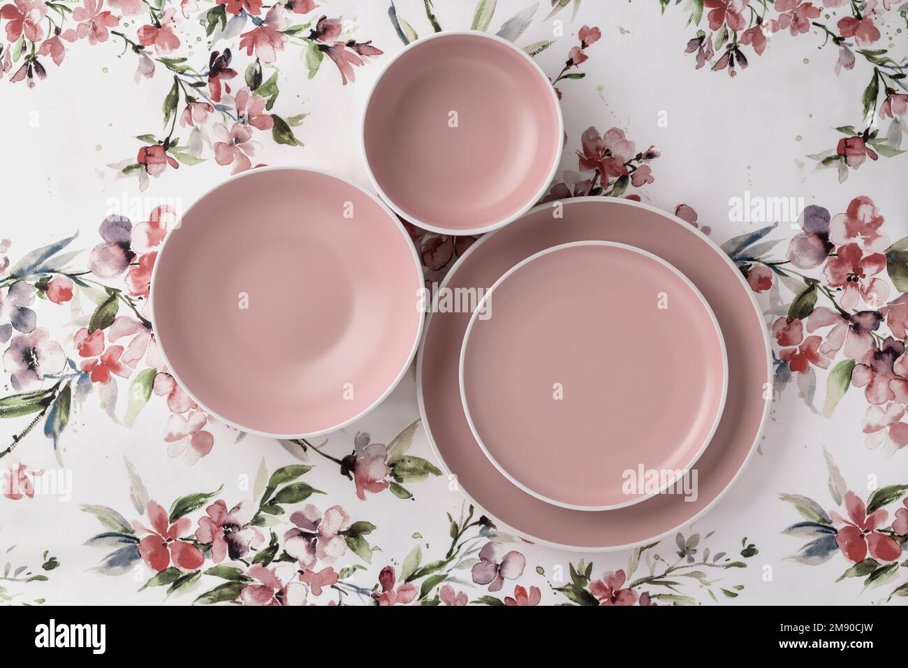 Empty clean plates on a white tablecloth with floral pattern, table top ...