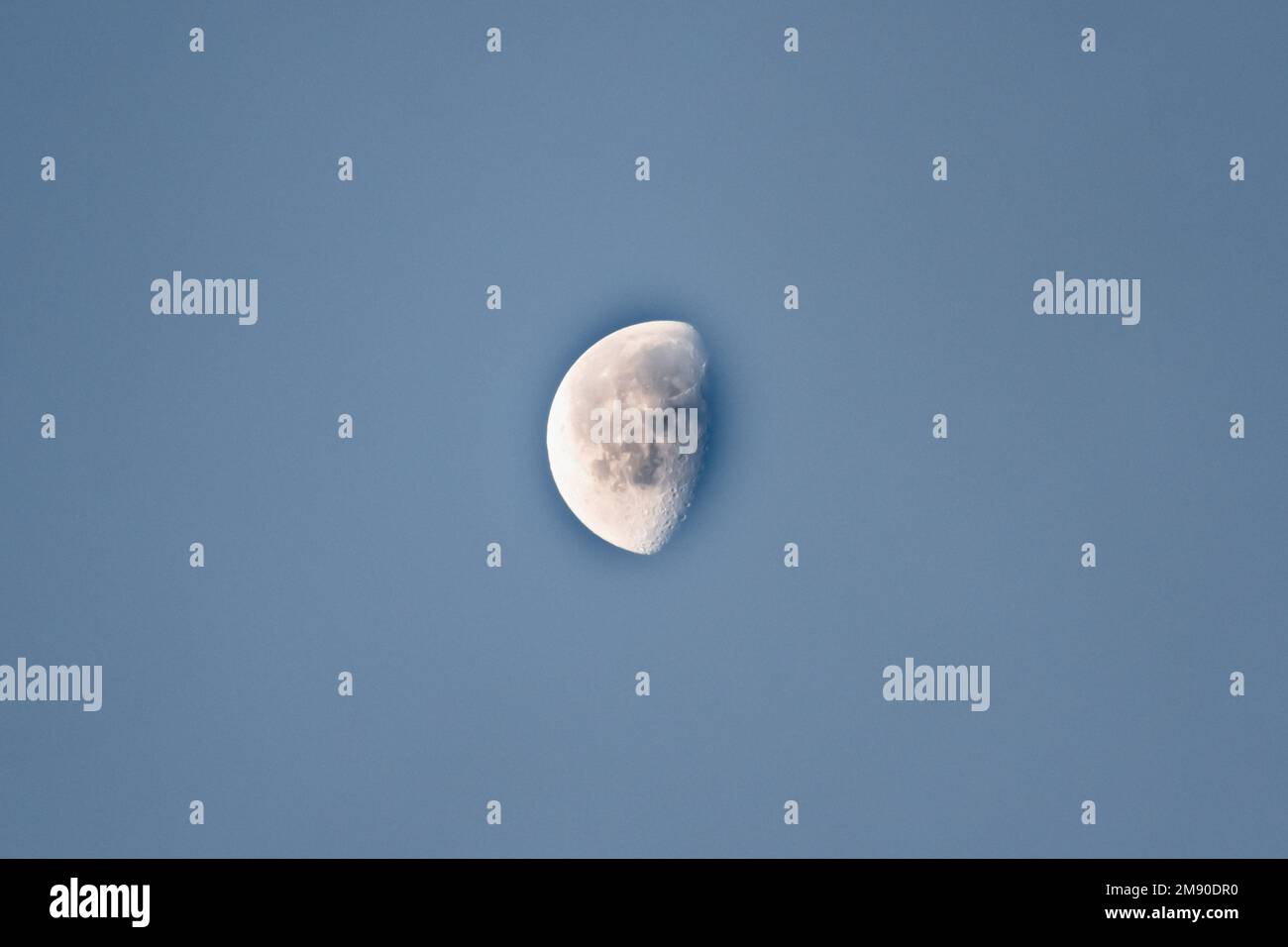 Waning moon in broad daylight with blue sky, in the morning at the ...