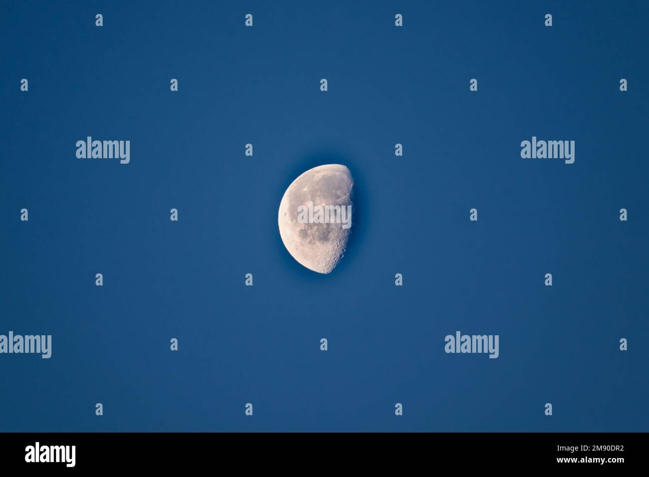 Waning moon in broad daylight with blue sky, in the morning at the ...