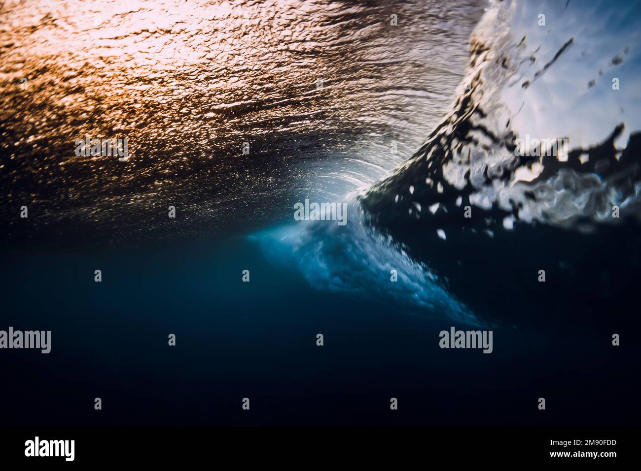 Barrel wave crash in ocean with sunset or sunrise light. Underwater ...