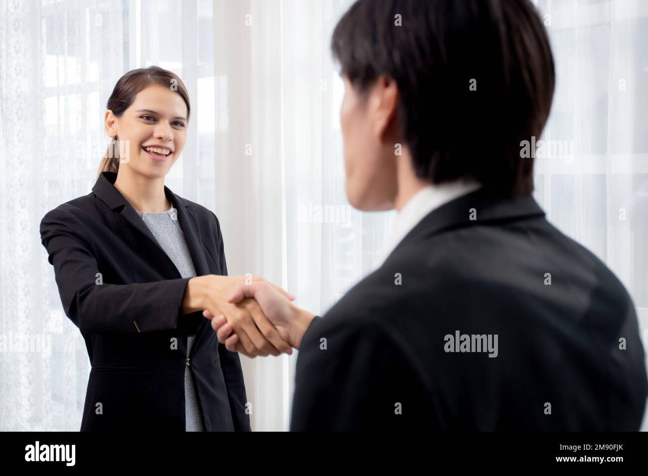 Happy business man and woman standing and shake hands while agreement ...