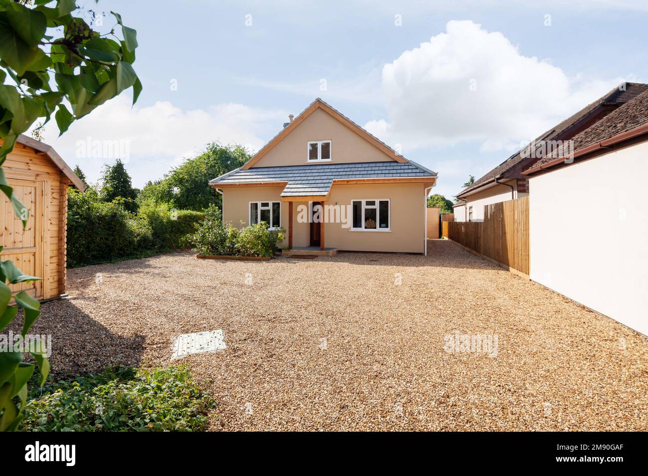 Detached house with large gravel driveway bathed in sunshine viewed ...