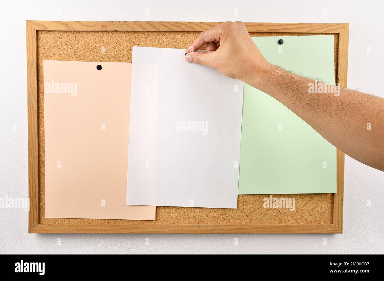 Businessman hands pin sticky notes on cork bulletin board at office ...