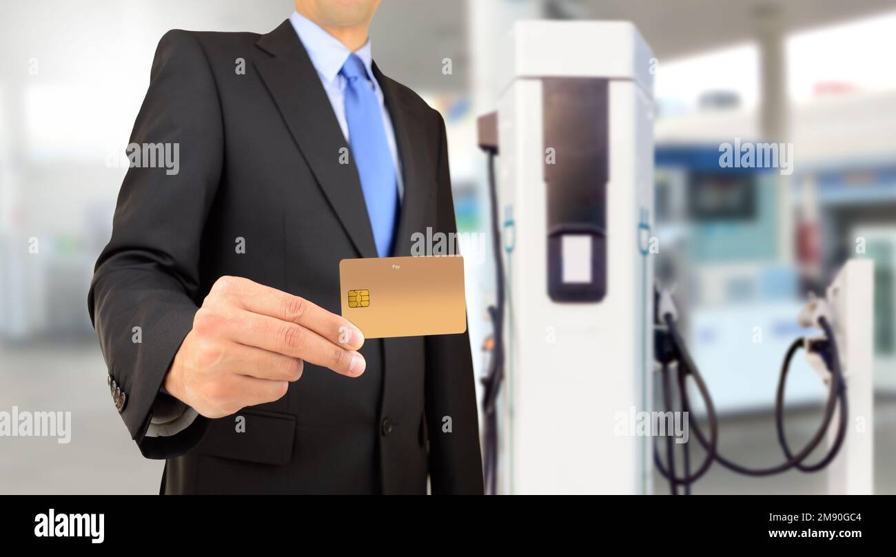 Hand of businessman holding golden credit card at electric car charging ...